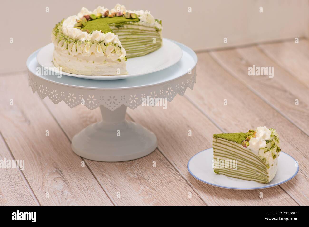 Matcha Mille Crepe Cake Presented On A Cake Holder With A Slice On A ...
