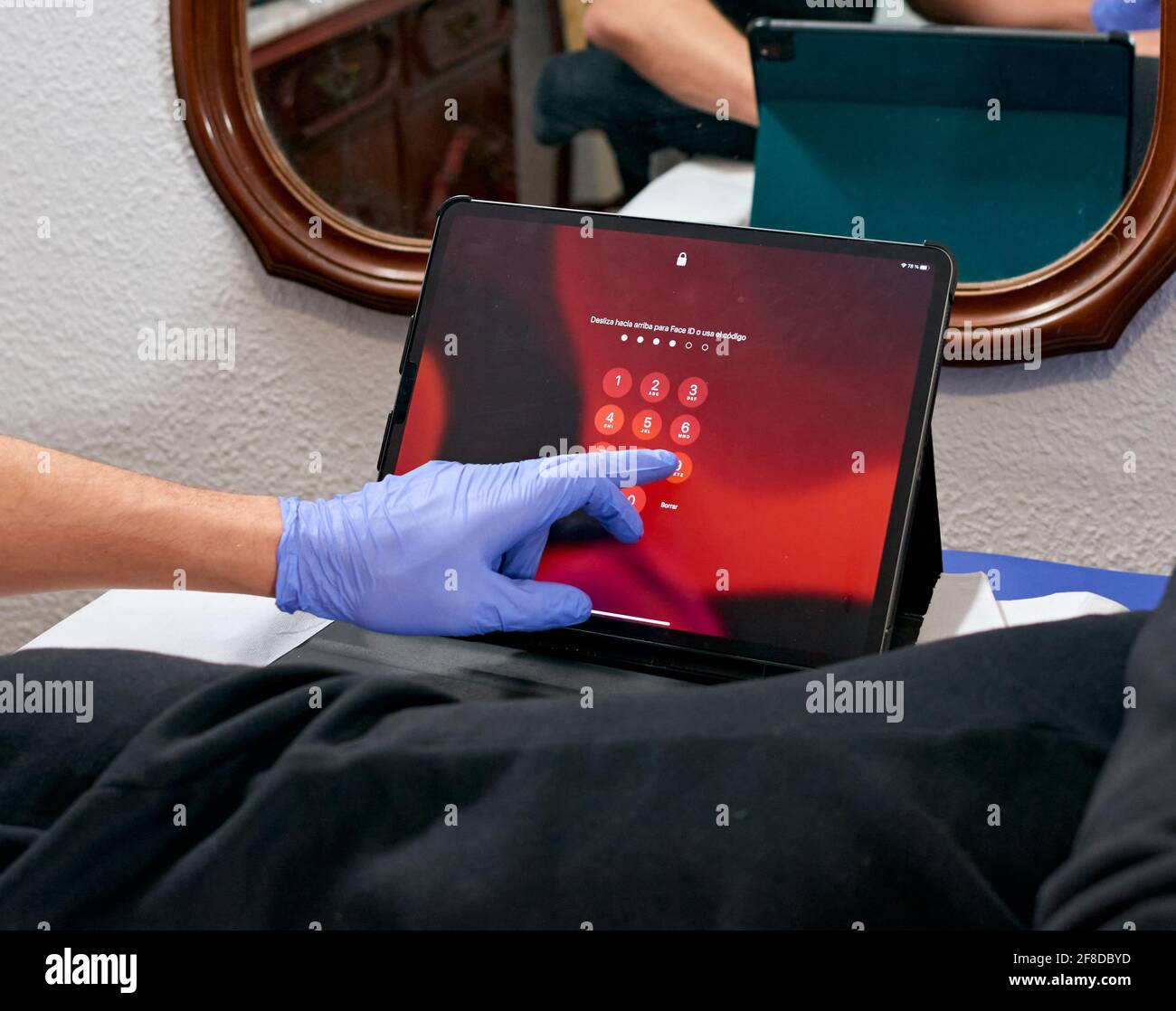 Hand in a blue glove opening the code of a tablet Stock Photo - Alamy