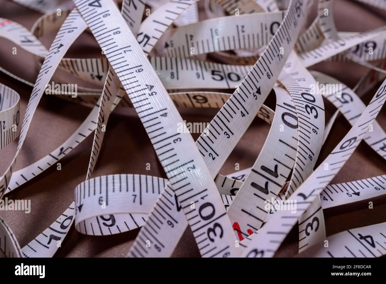 Tape measure rolled out randomly Stock Photo - Alamy