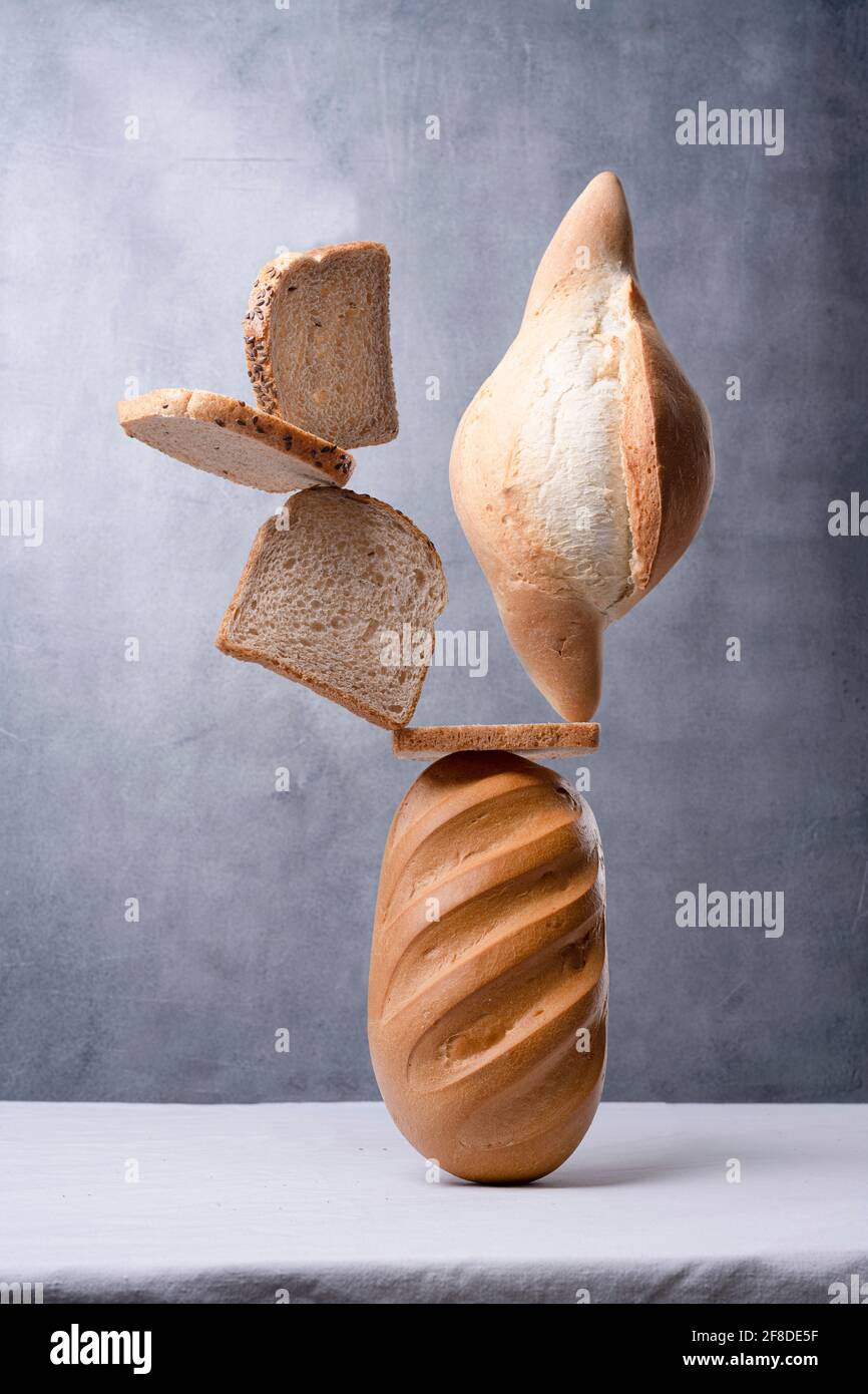 balancing bread on a table on a gray background Stock Photo - Alamy