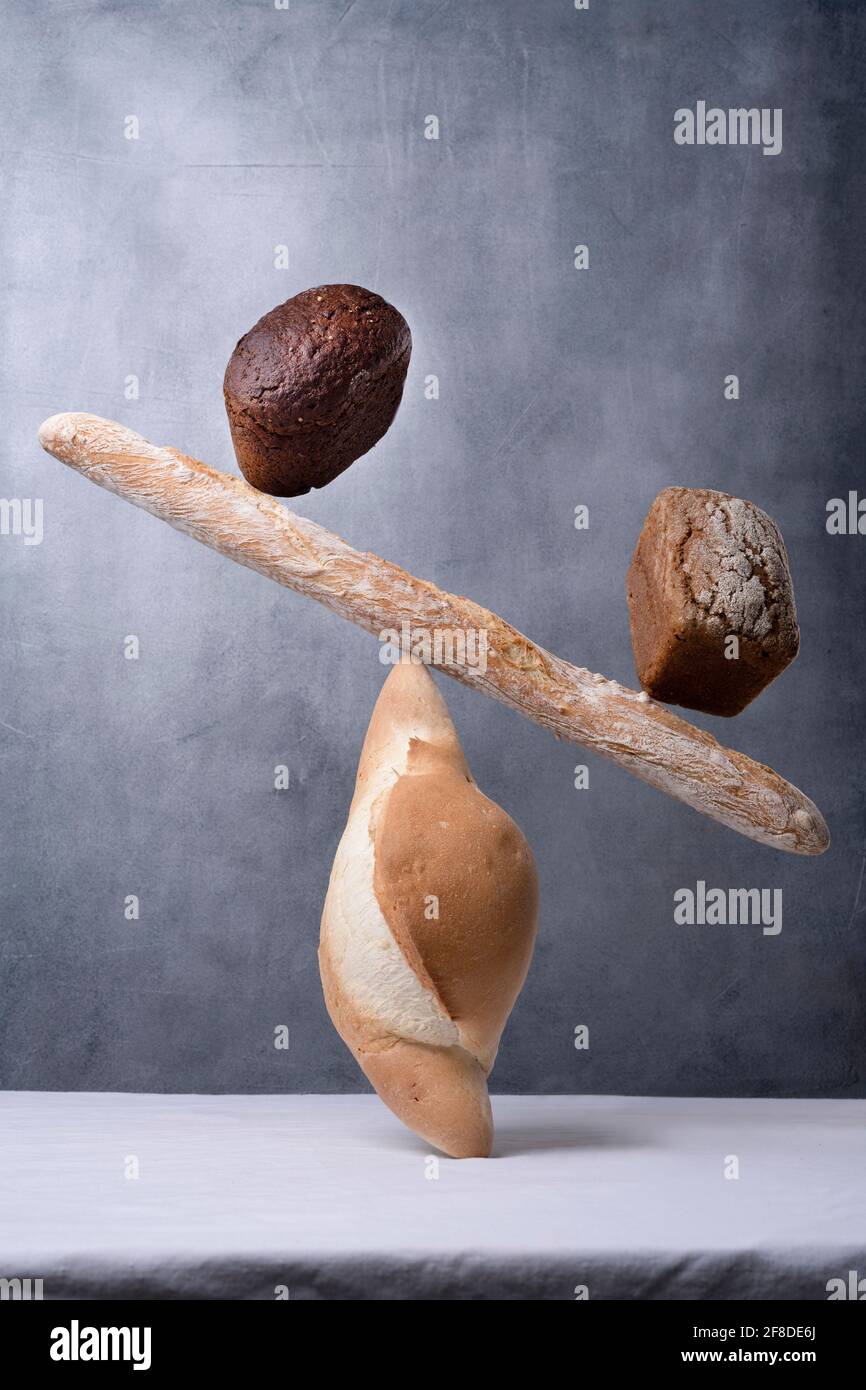 balancing bread on a table on a gray background Stock Photo - Alamy