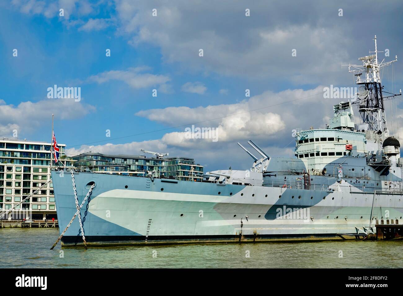 HMS Belfast on the River Thames with Union Jack flag flying at half ...