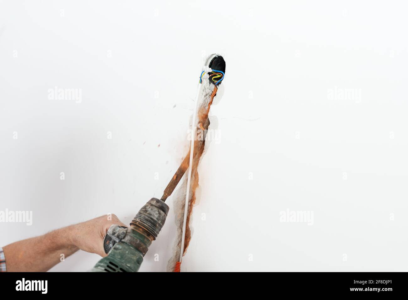 Closeup view of a machine drilling hole in the wall for electrical ...
