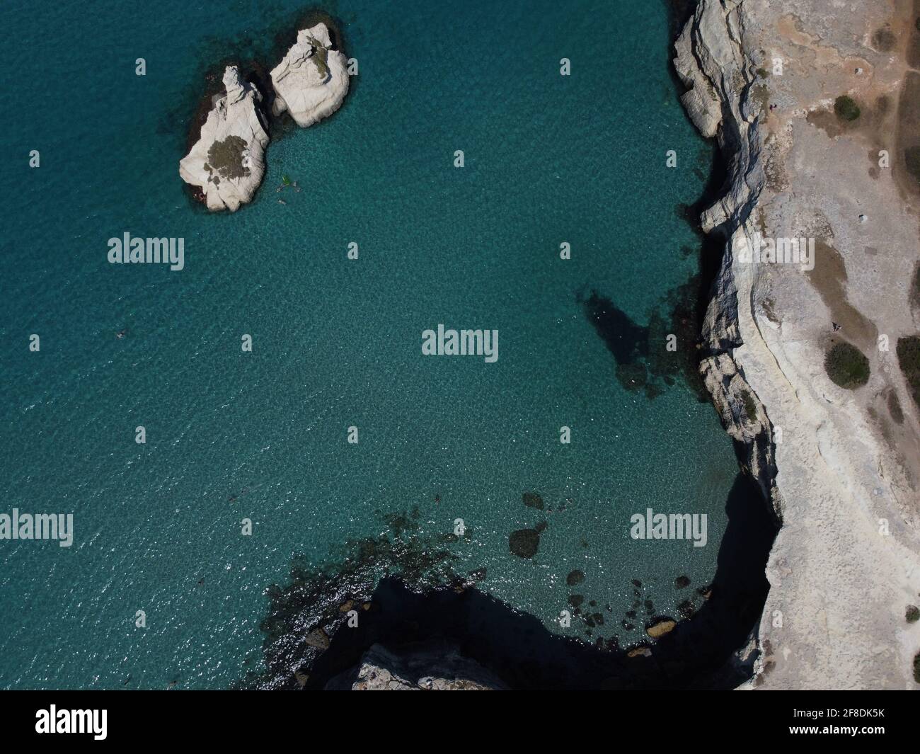 Aerial top view of mesmerizing ocean waters separated by coastal rocks ...