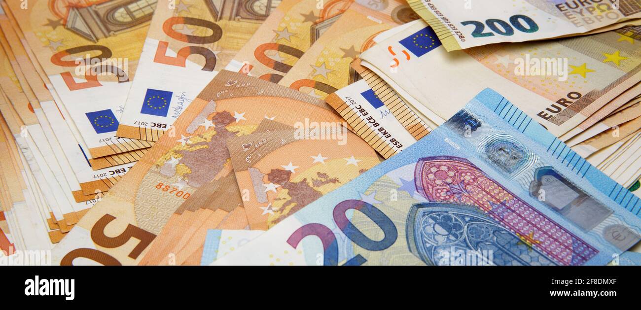large amount of euro cash of different denominations are on the table ...
