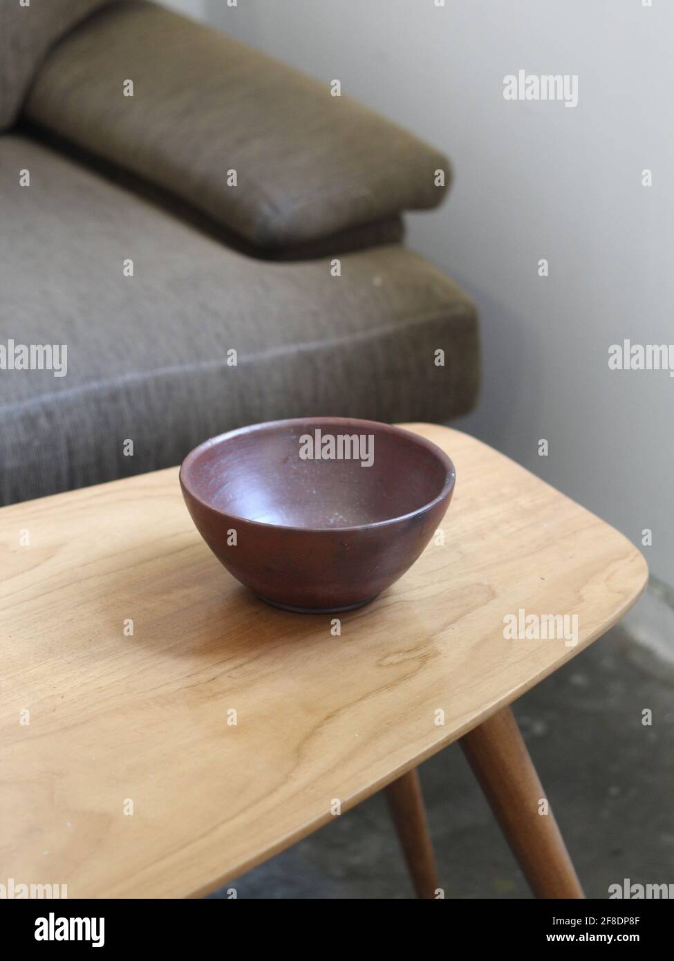 Brown bowl on the bright wood table beside the sofa Stock Photo - Alamy