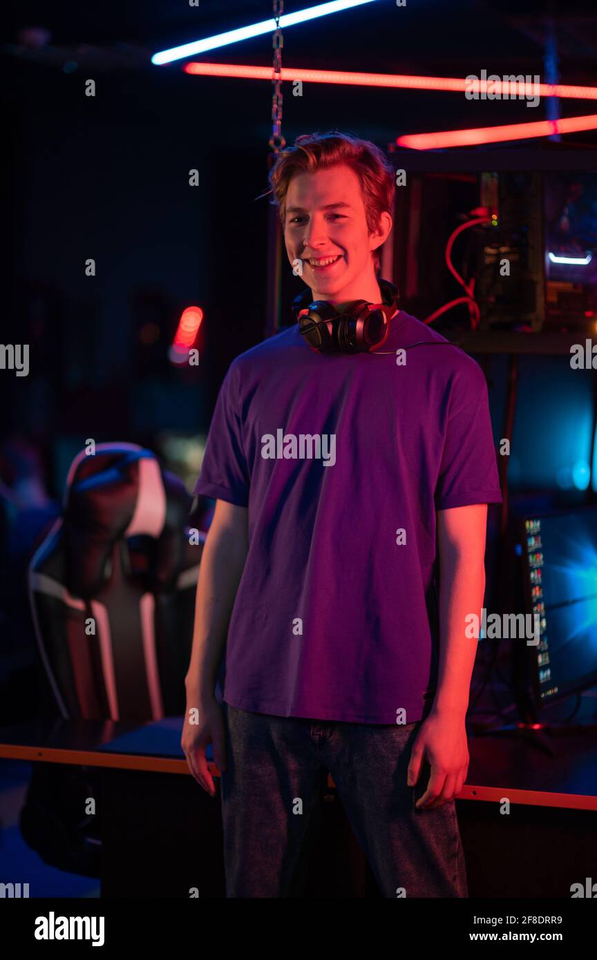 A cute guy streamer leads his live broadcast from the esports arena, a ...