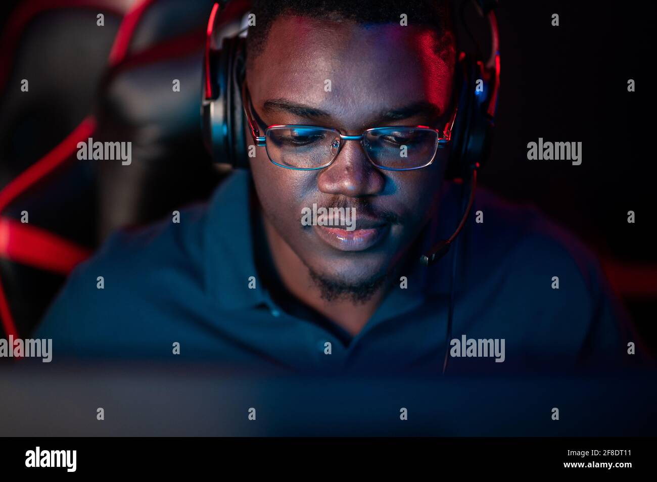 A close-up portrait of a handsome dark-skinned man wearing glasses and ...