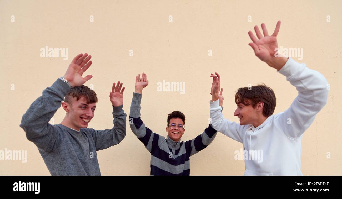 Cheerful friends from Spain dancing with their hands up and having fun ...