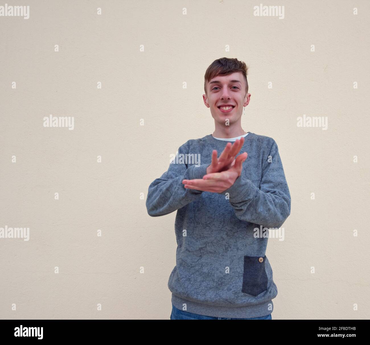 Cheerful Caucasian male from Spain standing and clapping hands on a ...