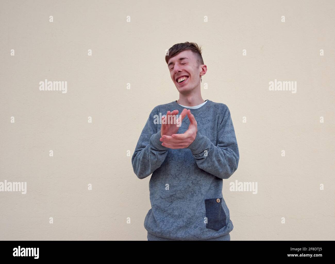 Cheerful Caucasian male from Spain standing and clapping hands on a ...