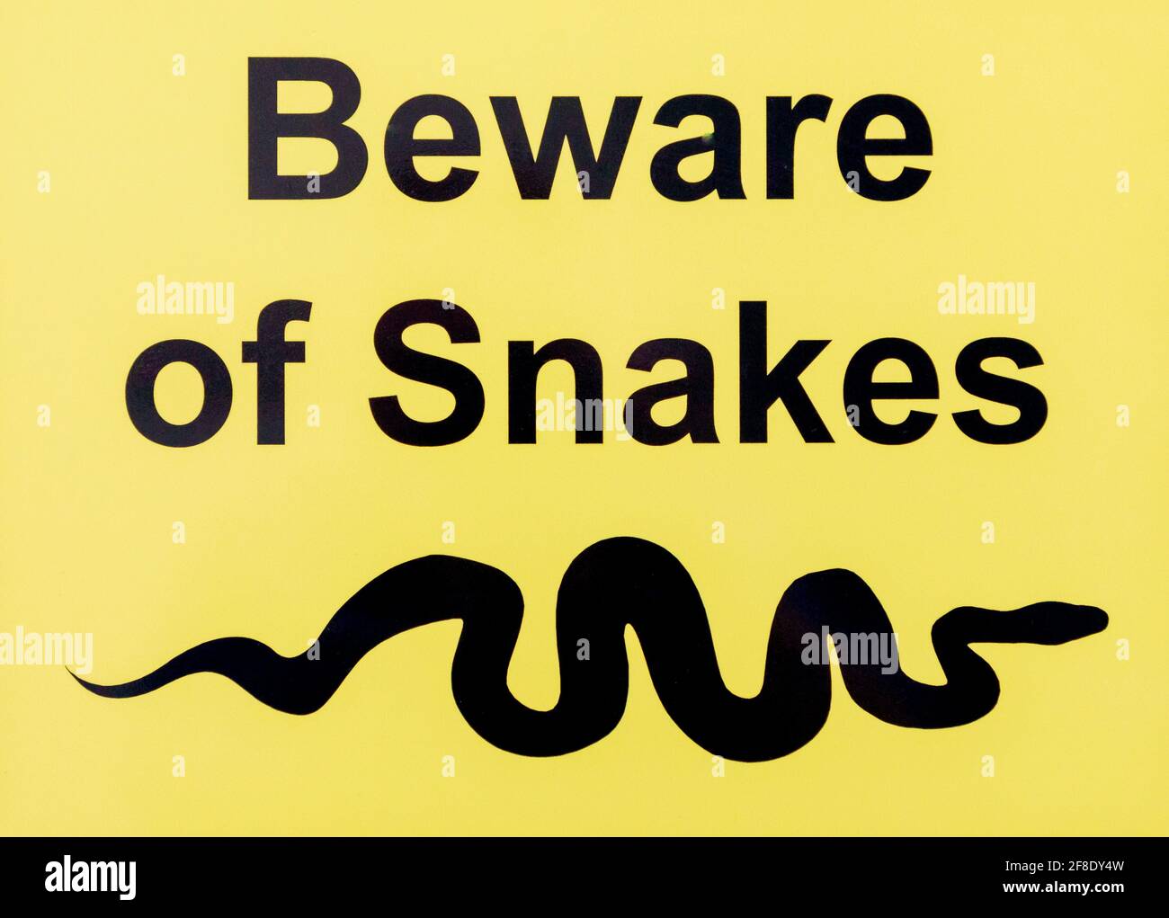 A yellow and black beware of snakes sign Stock Photo - Alamy