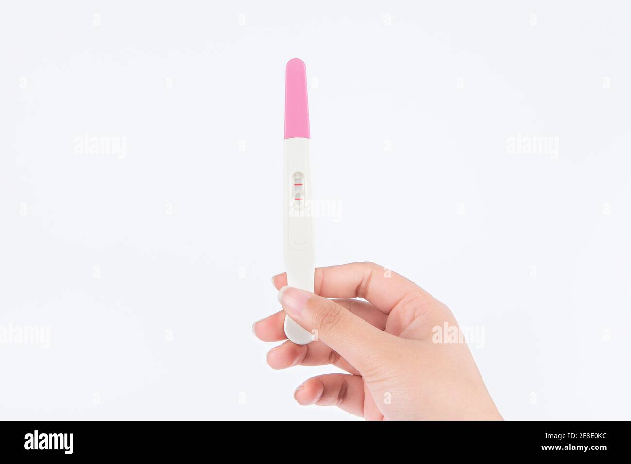 A woman's hand holding up a pregnancy test kit with positive result ...