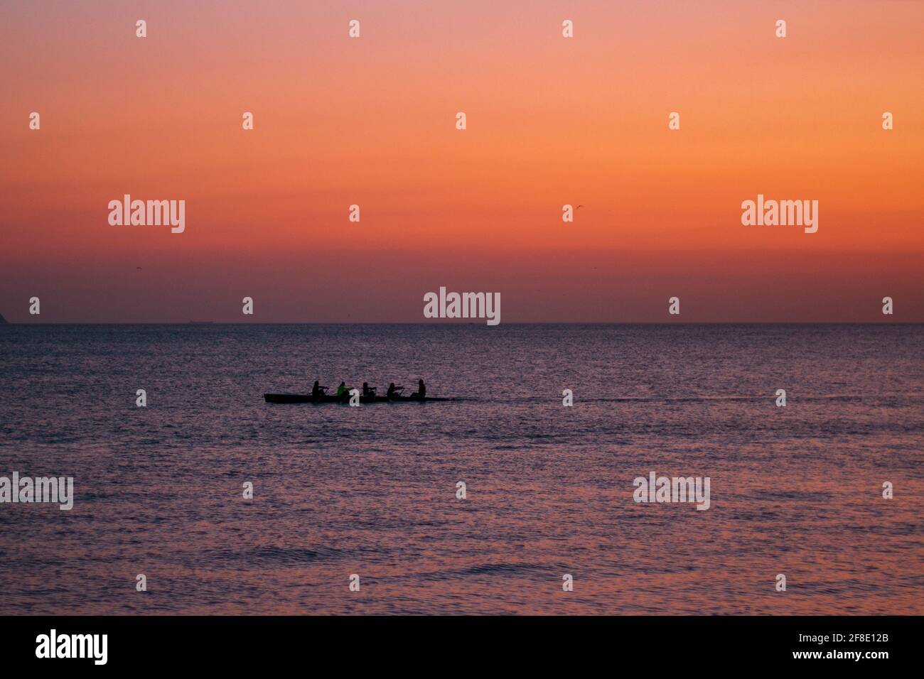 Rowing team practice at sunset. Copy space Stock Photo - Alamy