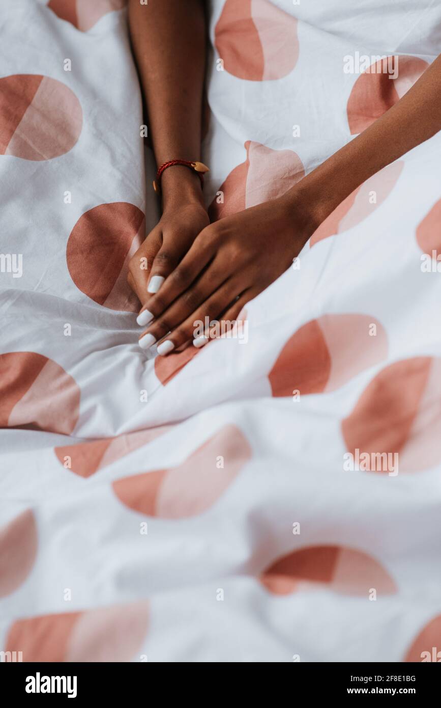 African female hands with white manicure on a bed Stock Photo - Alamy