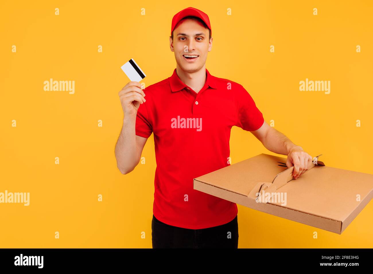 Delivery service man in red t-shirt and cap, gives food order and holds ...