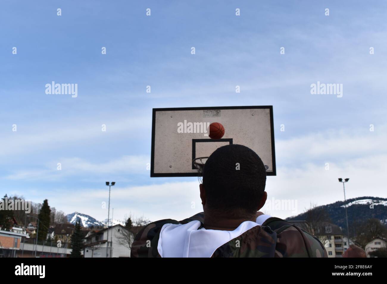 Back view of a basketball player looking at the ball falling into the ...