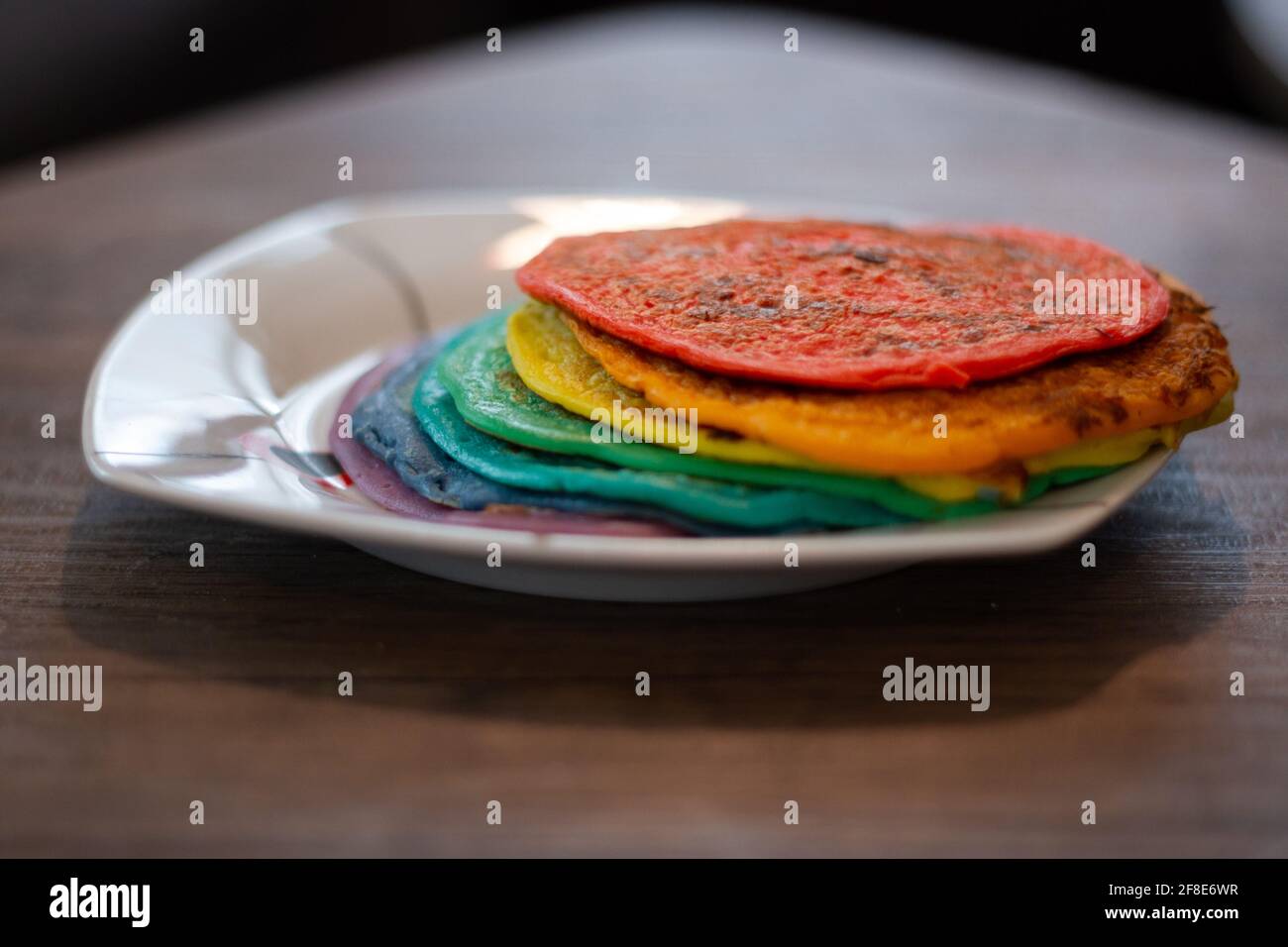 Dish With A Stack Of Rainbow Coloured Pancakes Stock Photo - Alamy