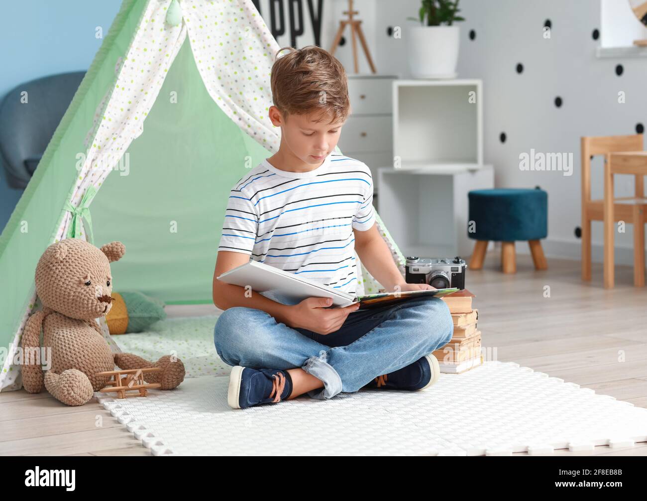 Cute little boy reading book at home Stock Photo - Alamy