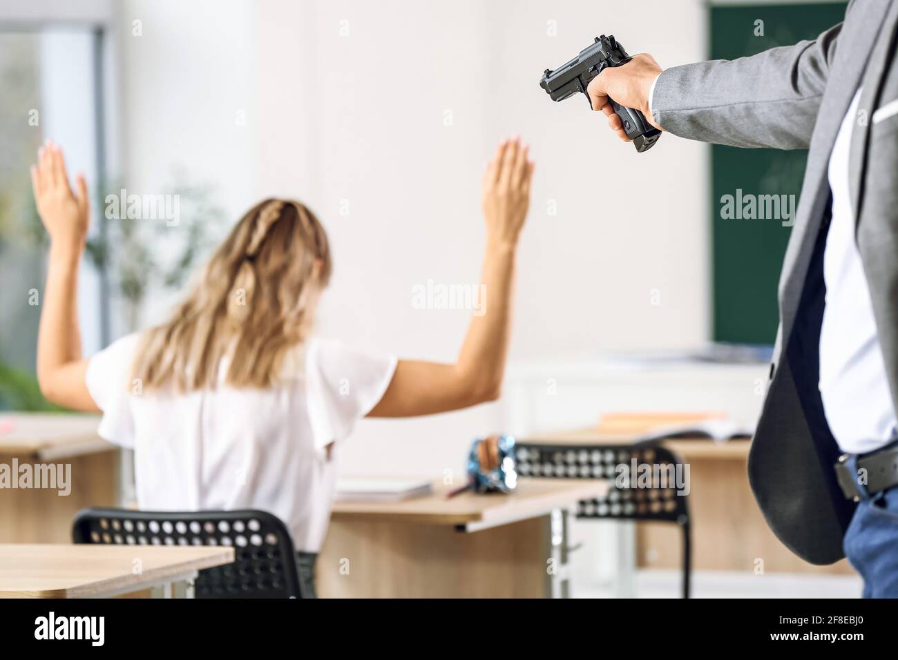 Male terrorist with gun in classroom. Problem of shooting at school ...