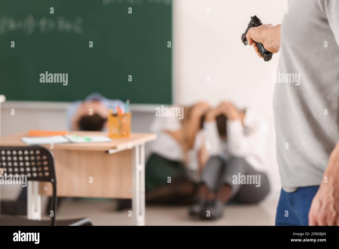 Male terrorist with gun in classroom. Problem of shooting at school ...