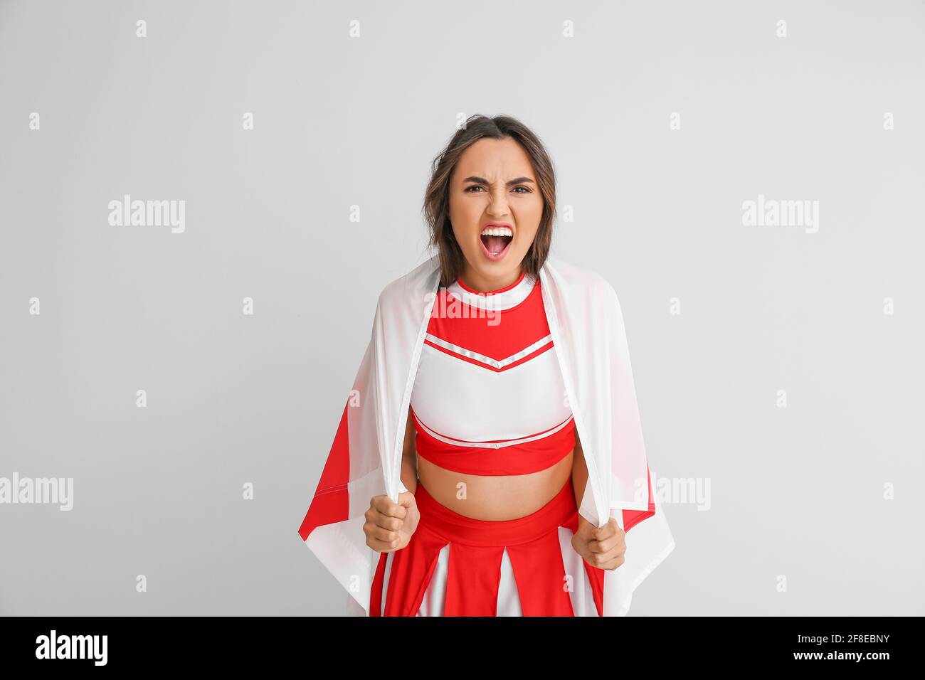 Aggressive cheerleader with the flag of England on light background ...