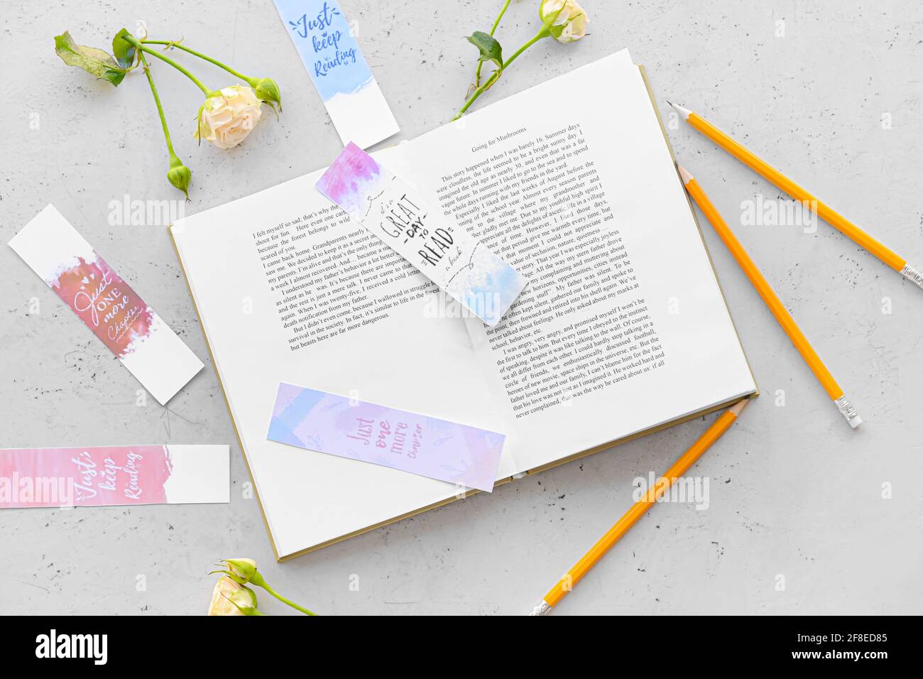 Book with bookmarks and flowers on light background Stock Photo - Alamy