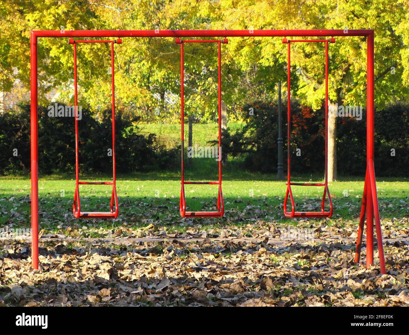 Three red swings on the children playground Stock Photo - Alamy