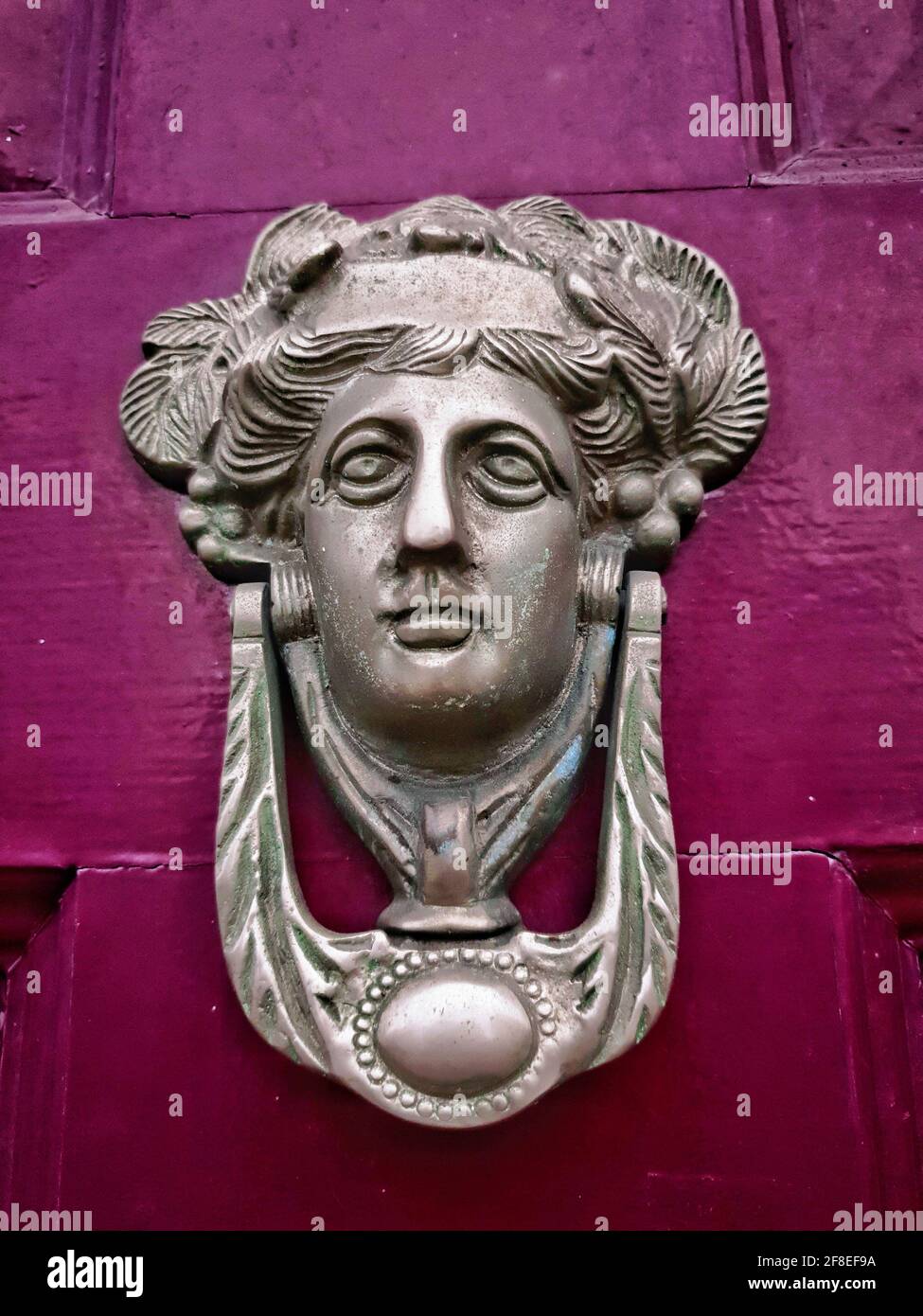 Female head door knocker on Georgian purple door Stock Photo - Alamy