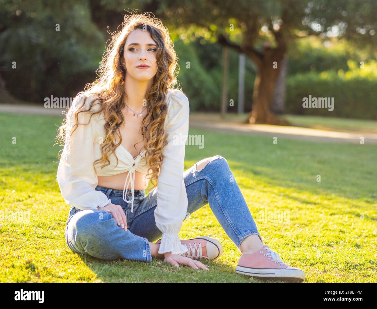 Pretty young lady in casual clothes spending leisure time in the spring ...