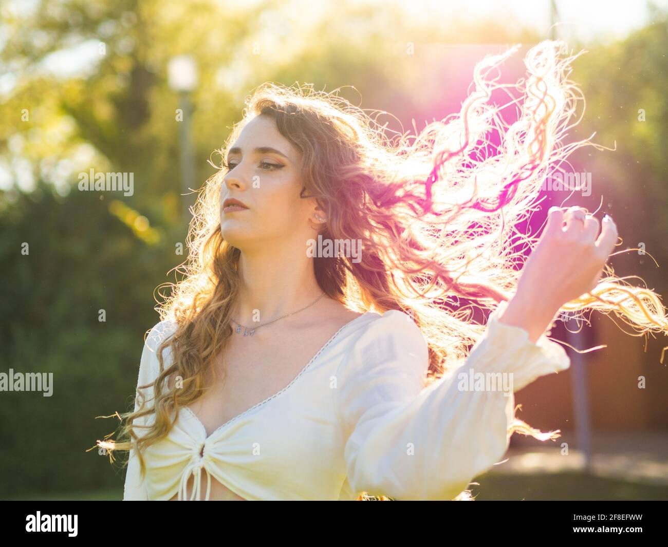 Elegant young lady with long hair flying and shining in the sun Stock ...