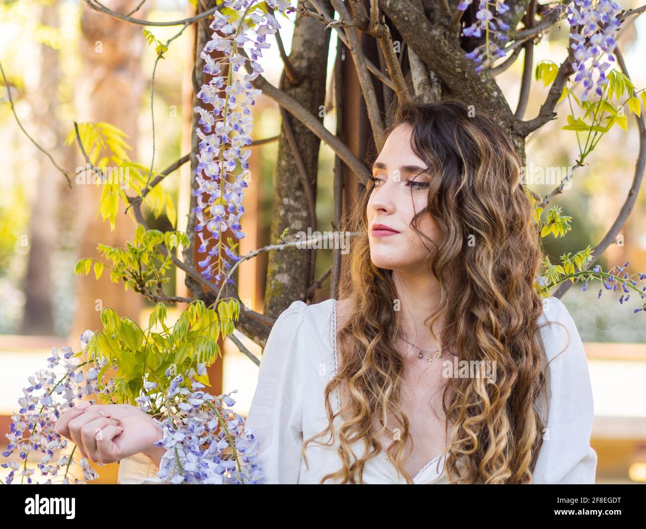 Closeup of a young attractive Spanish woman posing under the blooming ...