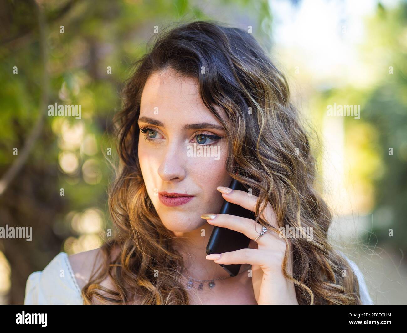 Headshot of a young pretty Spanish woman making a phone call Stock ...