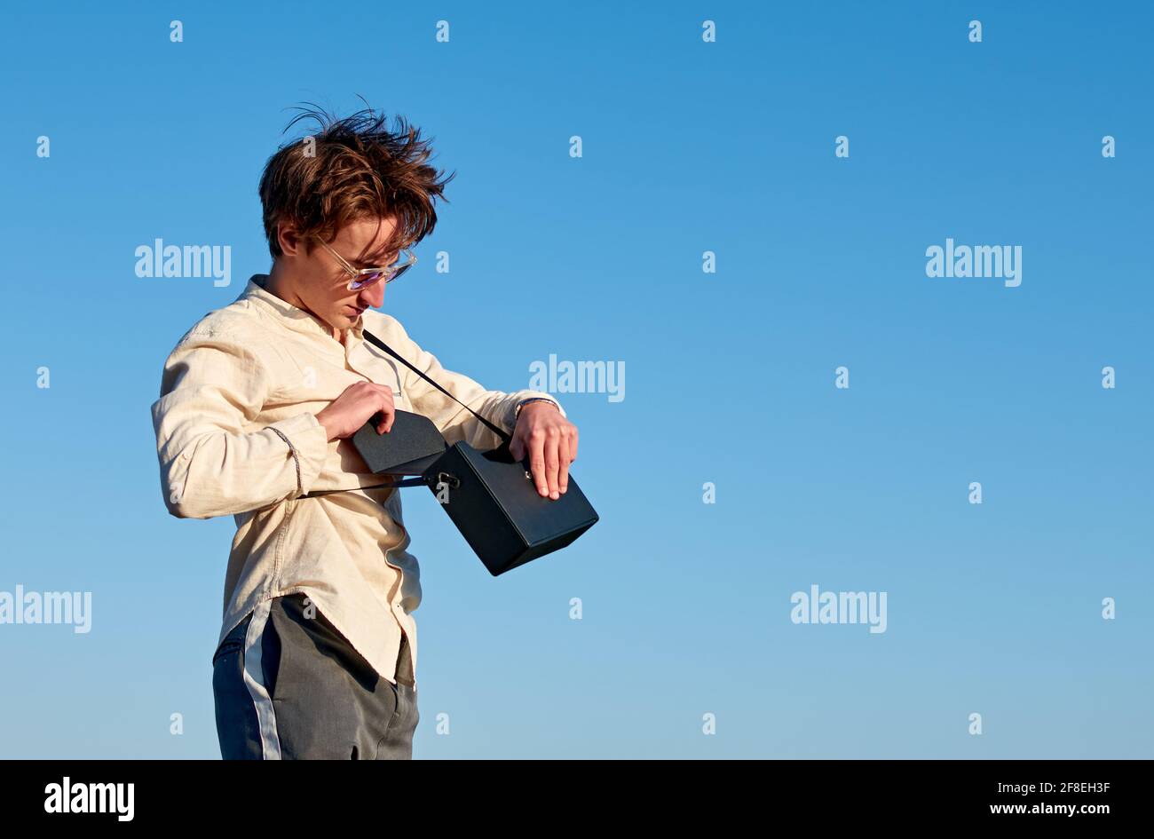 Caucasian man from Spain standing and putting something in his black ...