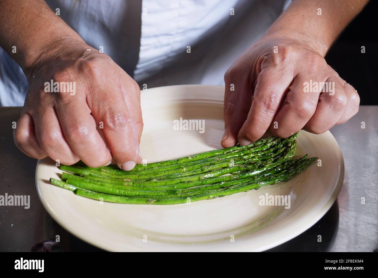 Chef putting asparagus on a plate Stock Photo - Alamy