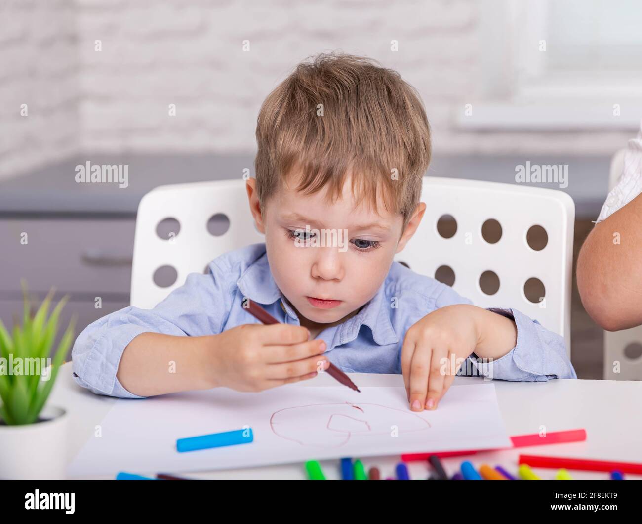 Concentrated boy drawing picture with with felt pen at home Stock Photo ...