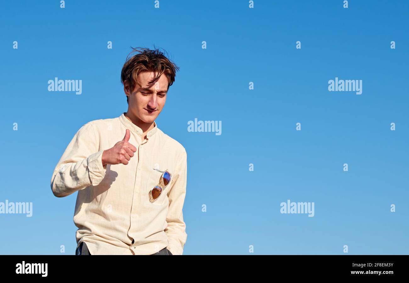 Caucasian man from Spain making a thumbs up sign on clear sky ...