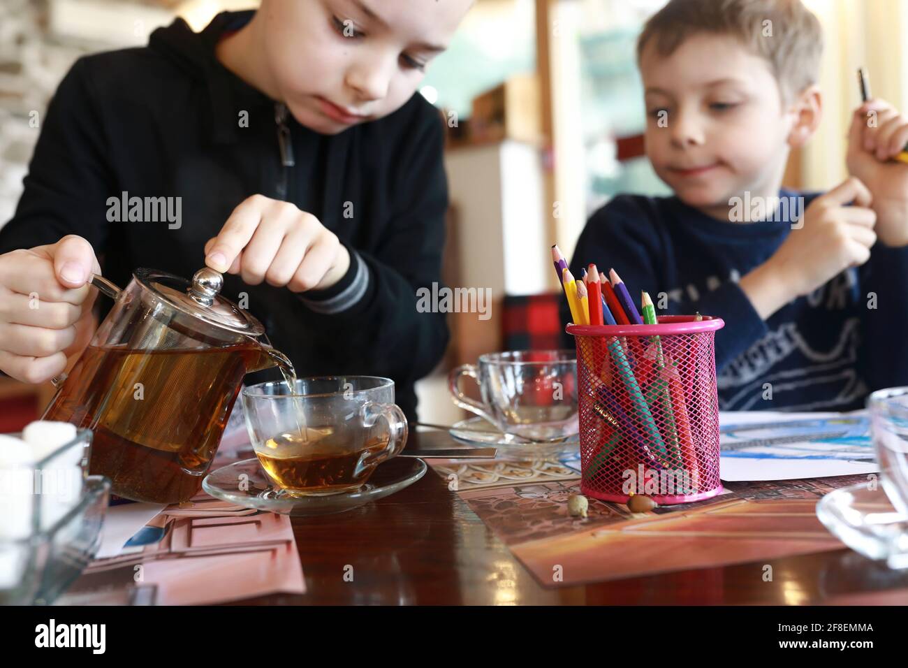Portrait of child pouring tea in cafe Stock Photo - Alamy