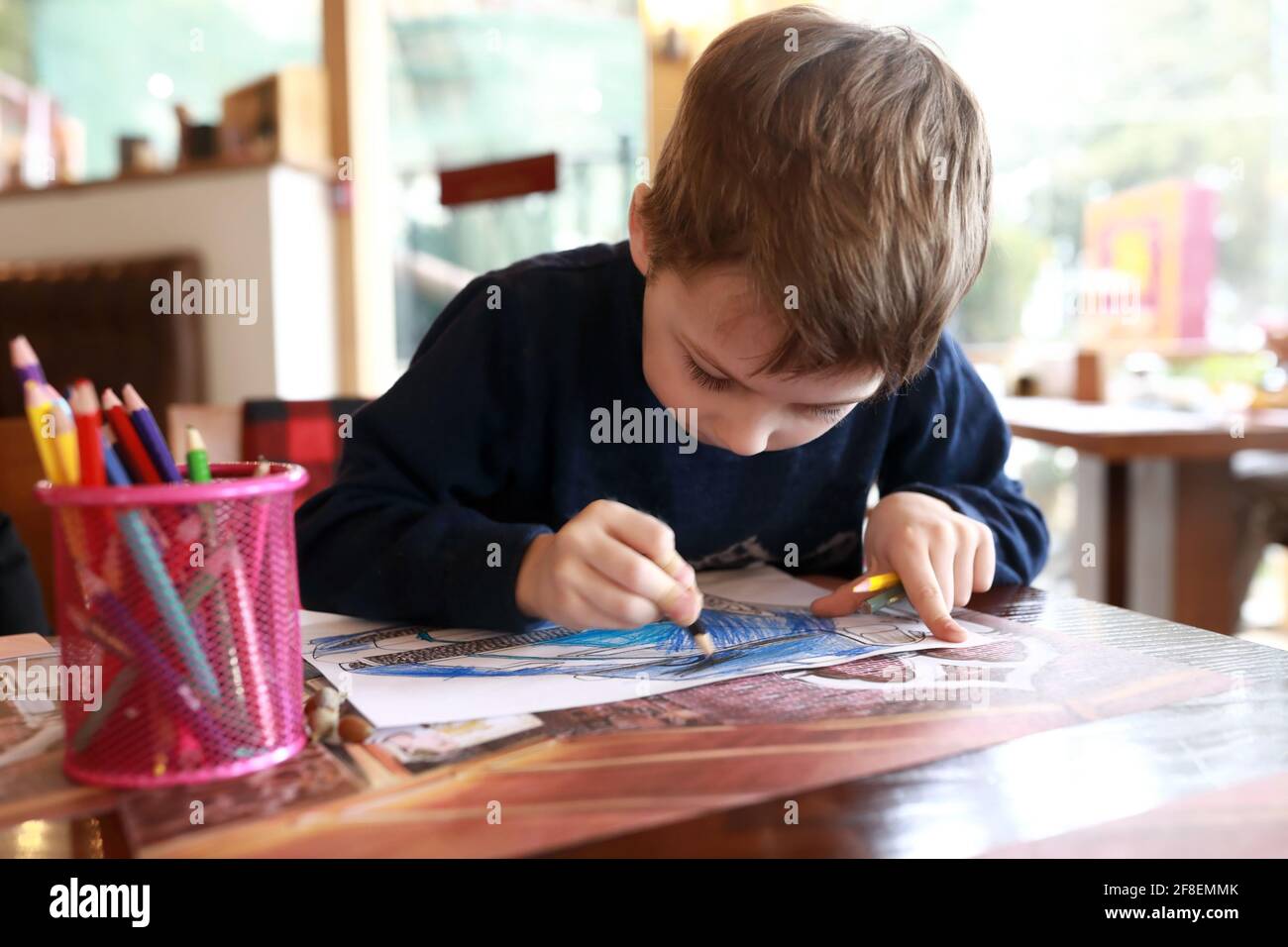Portrait of boy drawing with pencils in cafe Stock Photo - Alamy