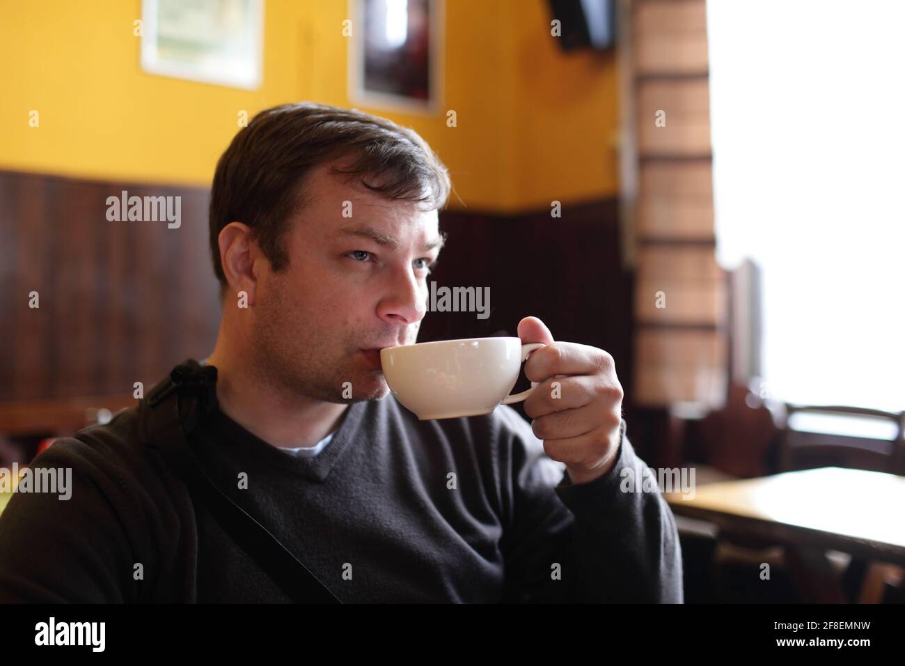 The man drinks tea in the restaurant Stock Photo - Alamy