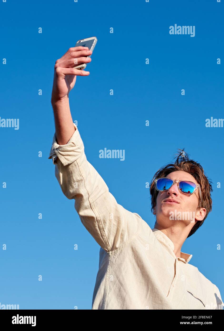 Vertical shot of a Spanish white man with glasses and a beige shirt ...