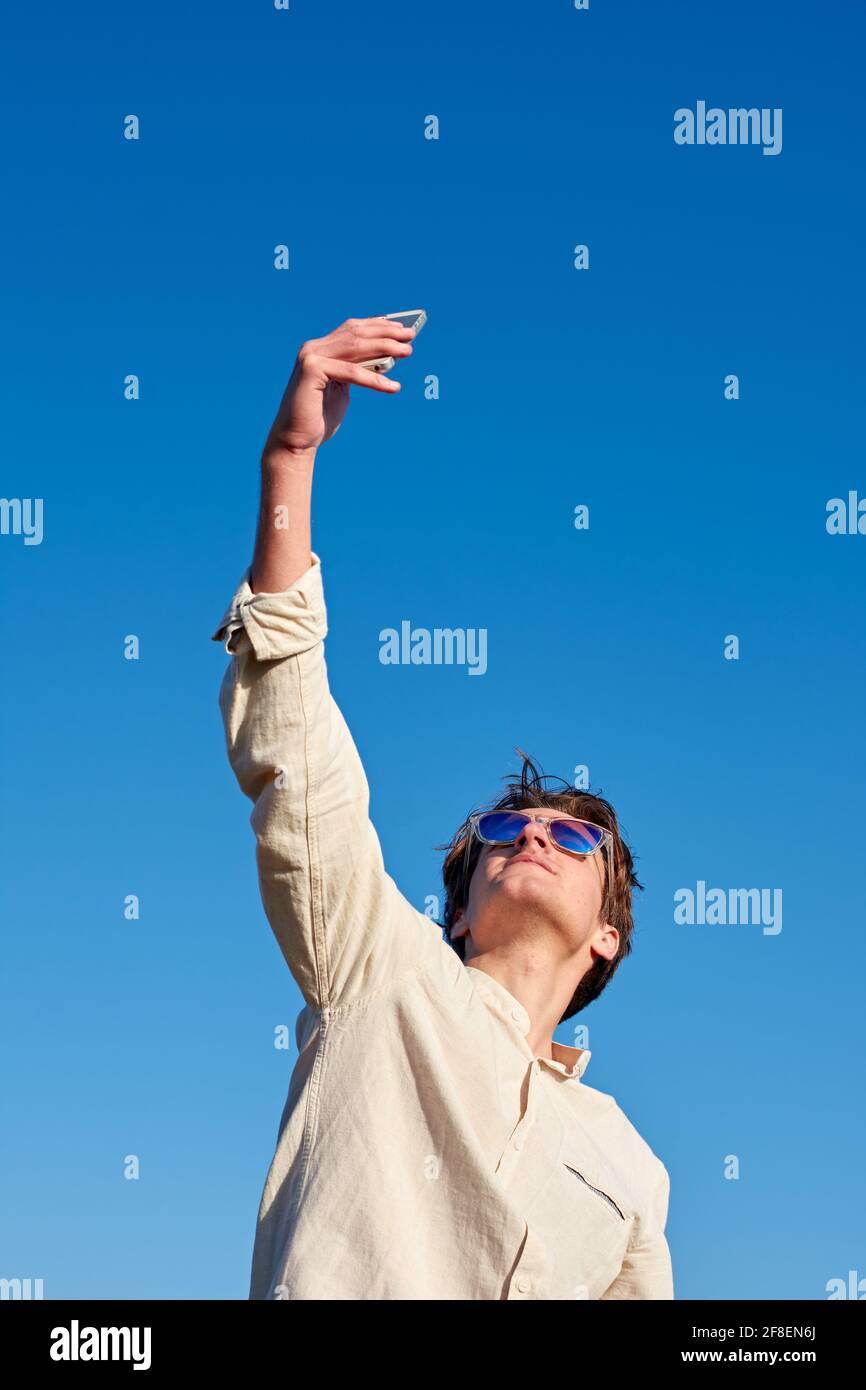 Vertical shot of a Spanish white man with glasses and a beige shirt ...