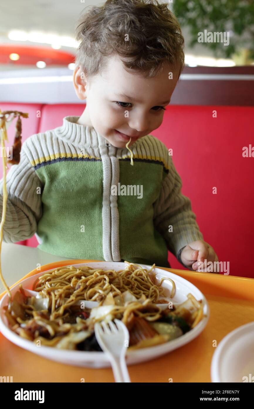 Portrait of kid with spaghetti in the restaurant Stock Photo - Alamy