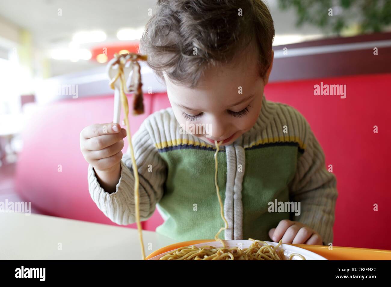Portrait of child with spaghetti in the restaurant Stock Photo - Alamy