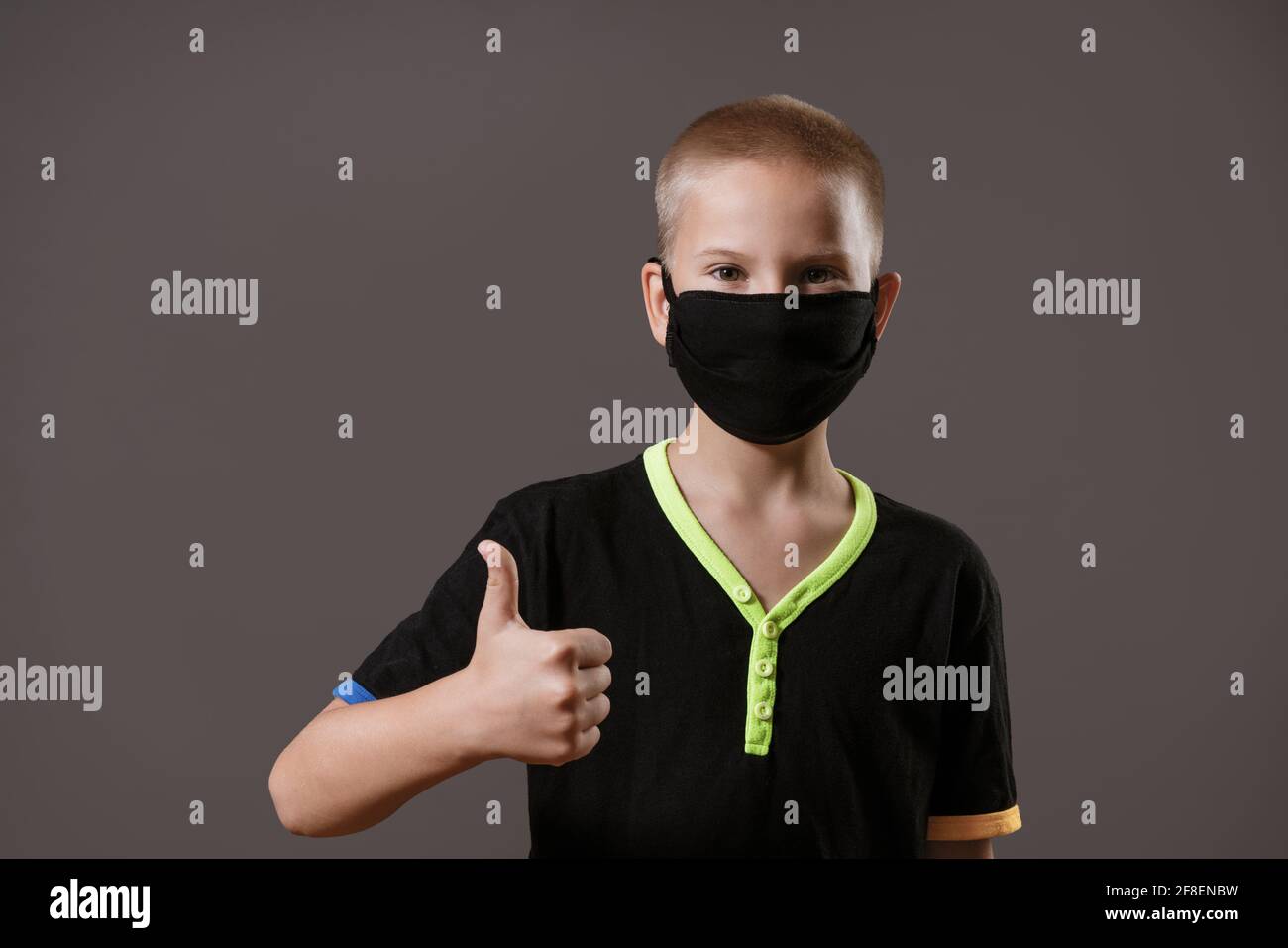Portrait of a young guy in a black mask shows a hand gesture that ...
