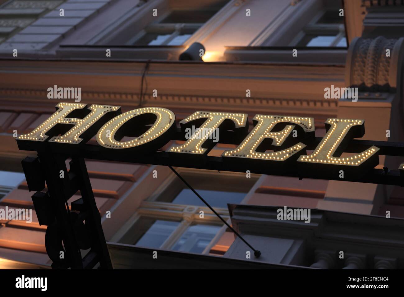 Illuminated yellow hotel sign on the wall of building Stock Photo - Alamy
