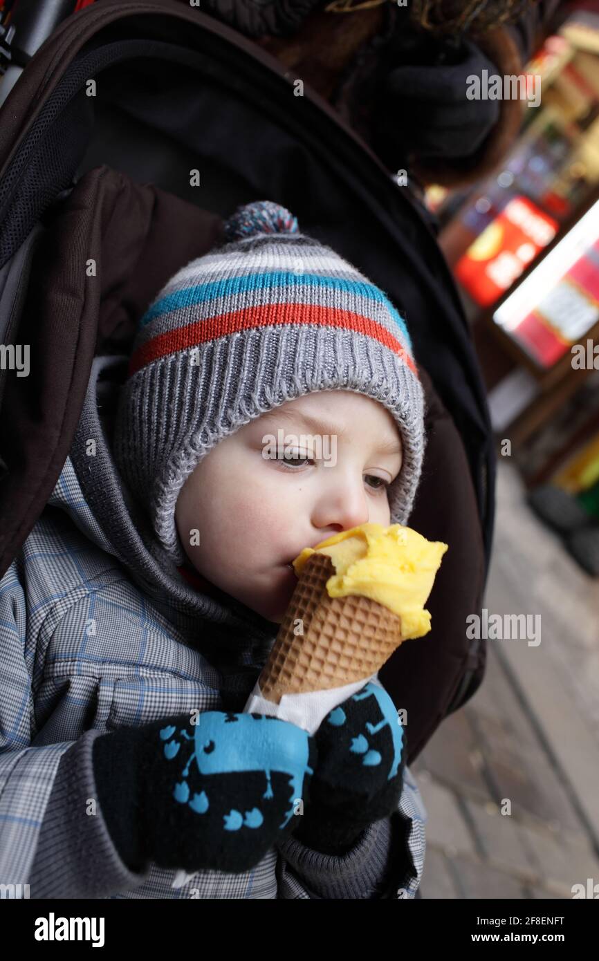 Child eating ice cream on the street in city Stock Photo - Alamy