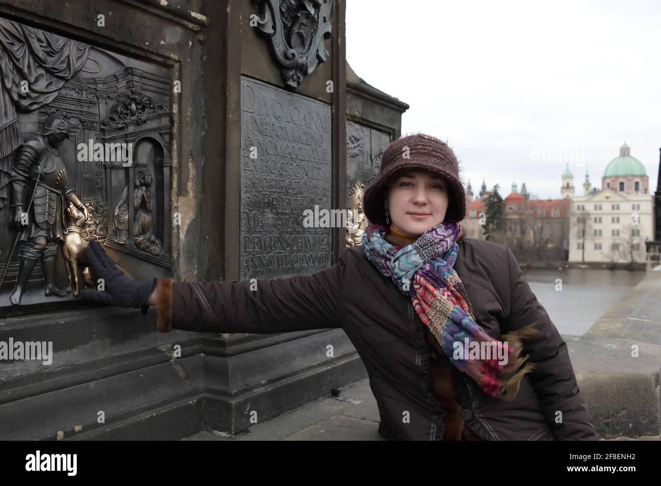 Woman touching sculpture on the Charles bridge in Prague Stock Photo ...