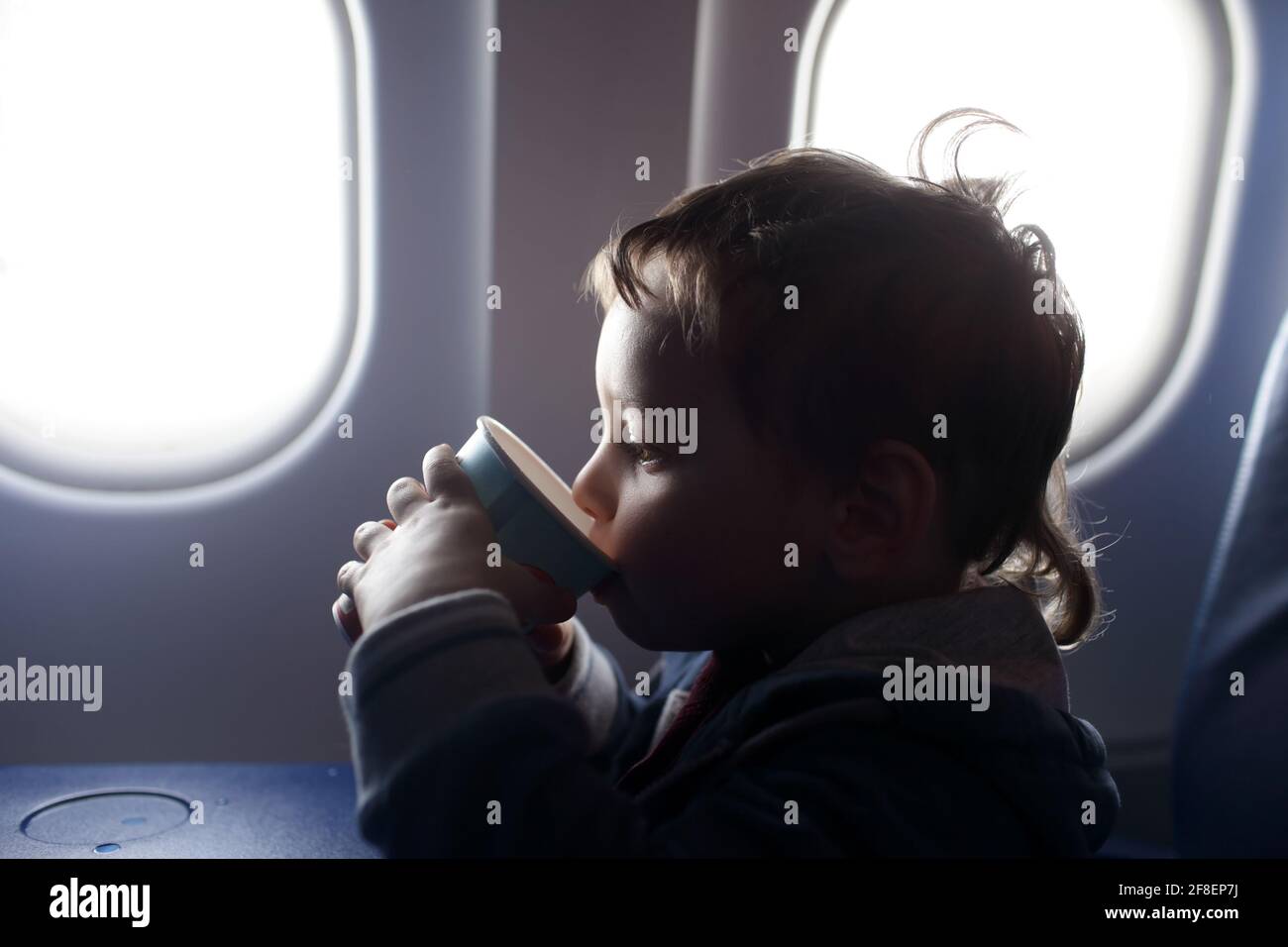 The boy drinks tea in the airplane Stock Photo - Alamy