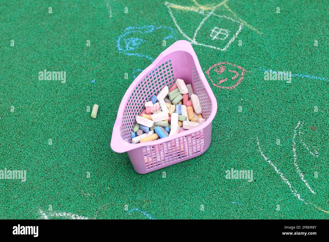 Colorful crayons in the box on the green pavement Stock Photo - Alamy